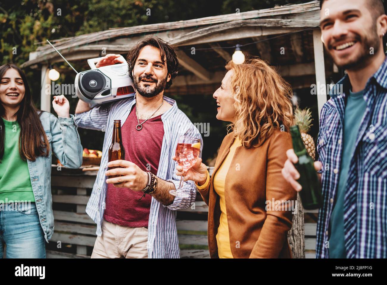 Cheerful friends talking and drinking beers and cocktails at beach ...
