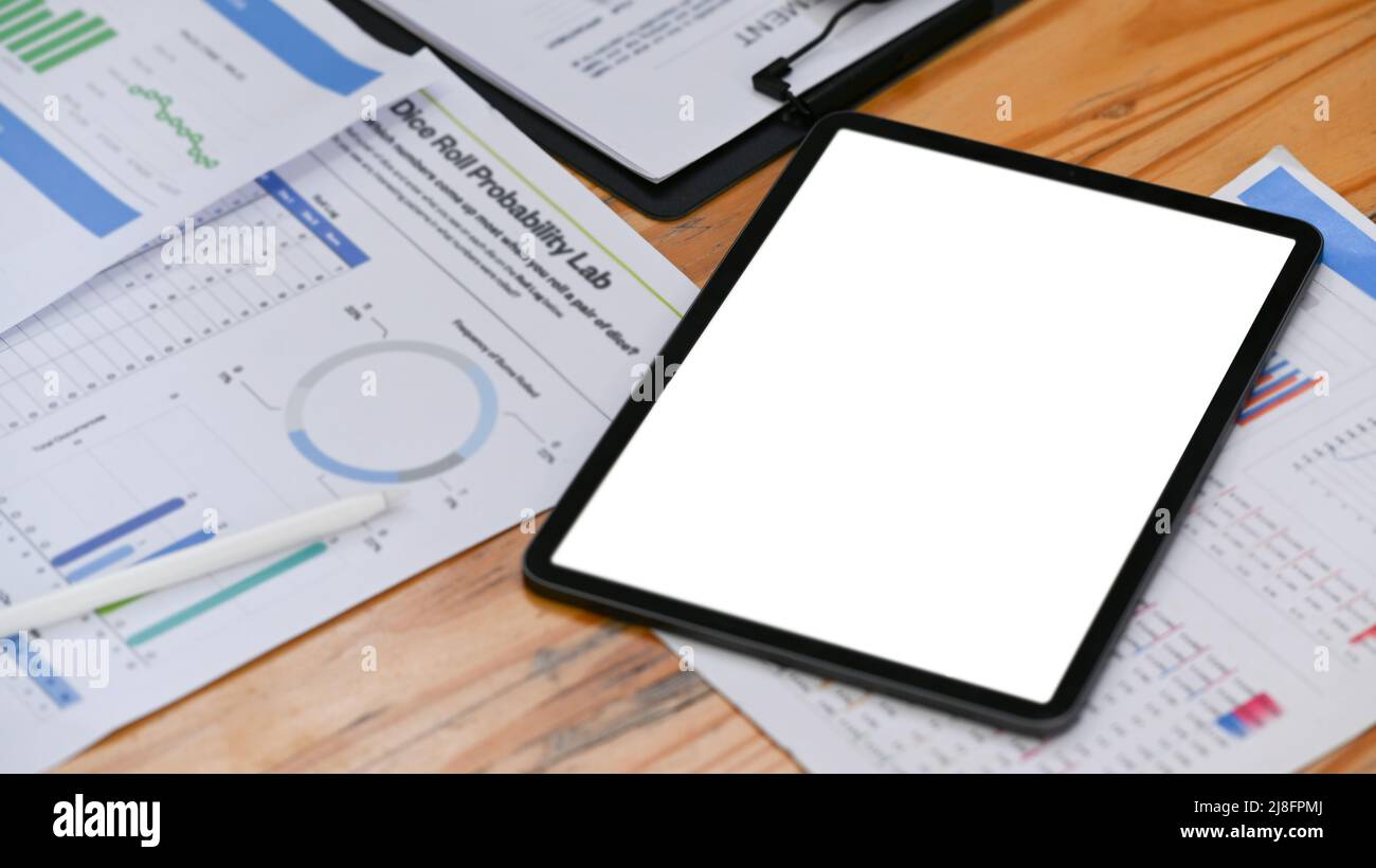 Digital tablet with blank screen and financial documents on office desk ...