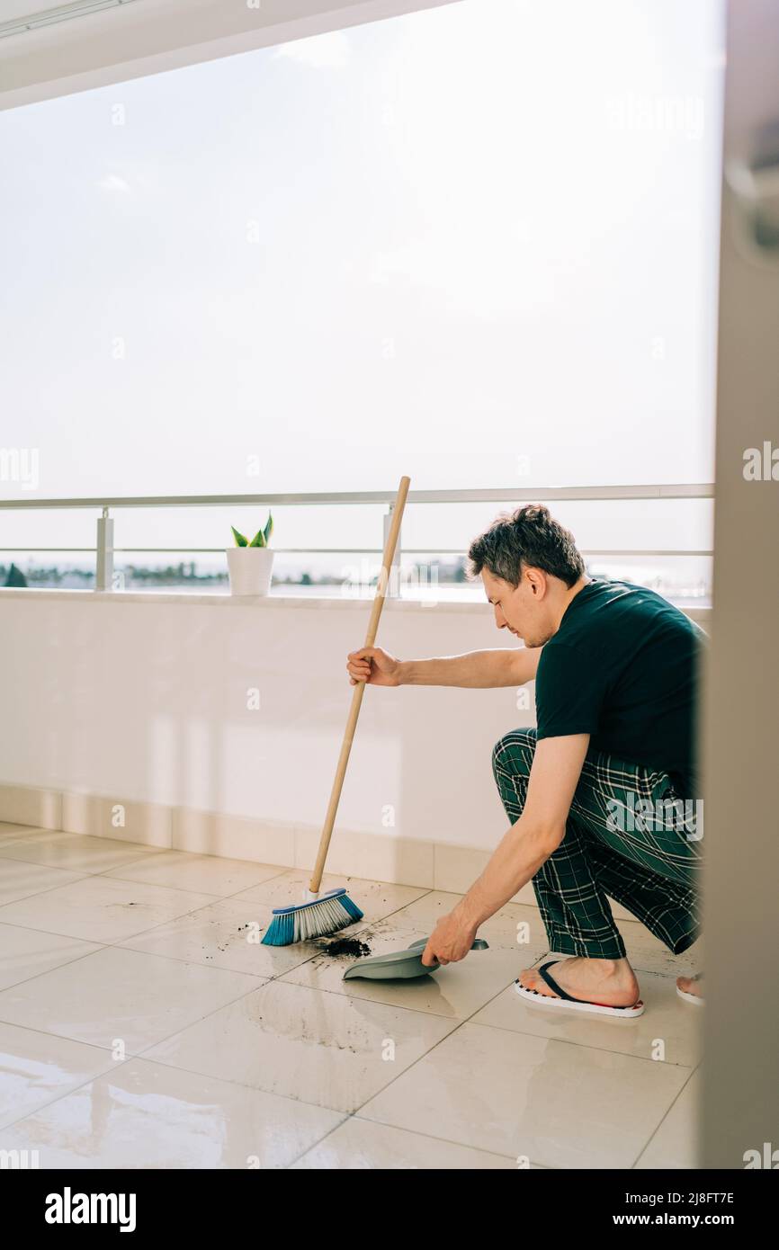 Man wiping floor with the mop. Janitor washing the dirty floors. Guy ...