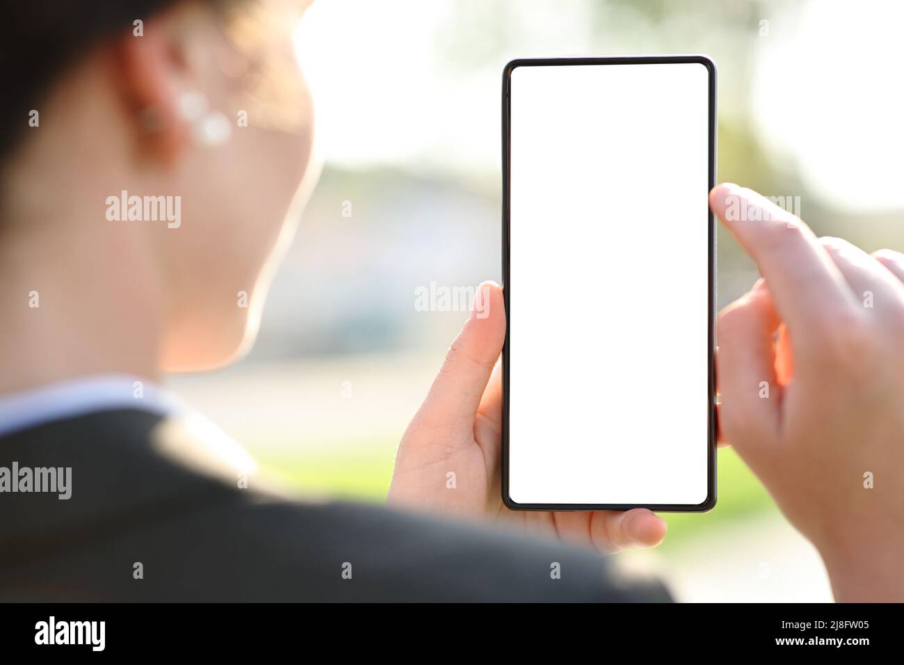Back view close up of an executive using phone showing blank screen ...
