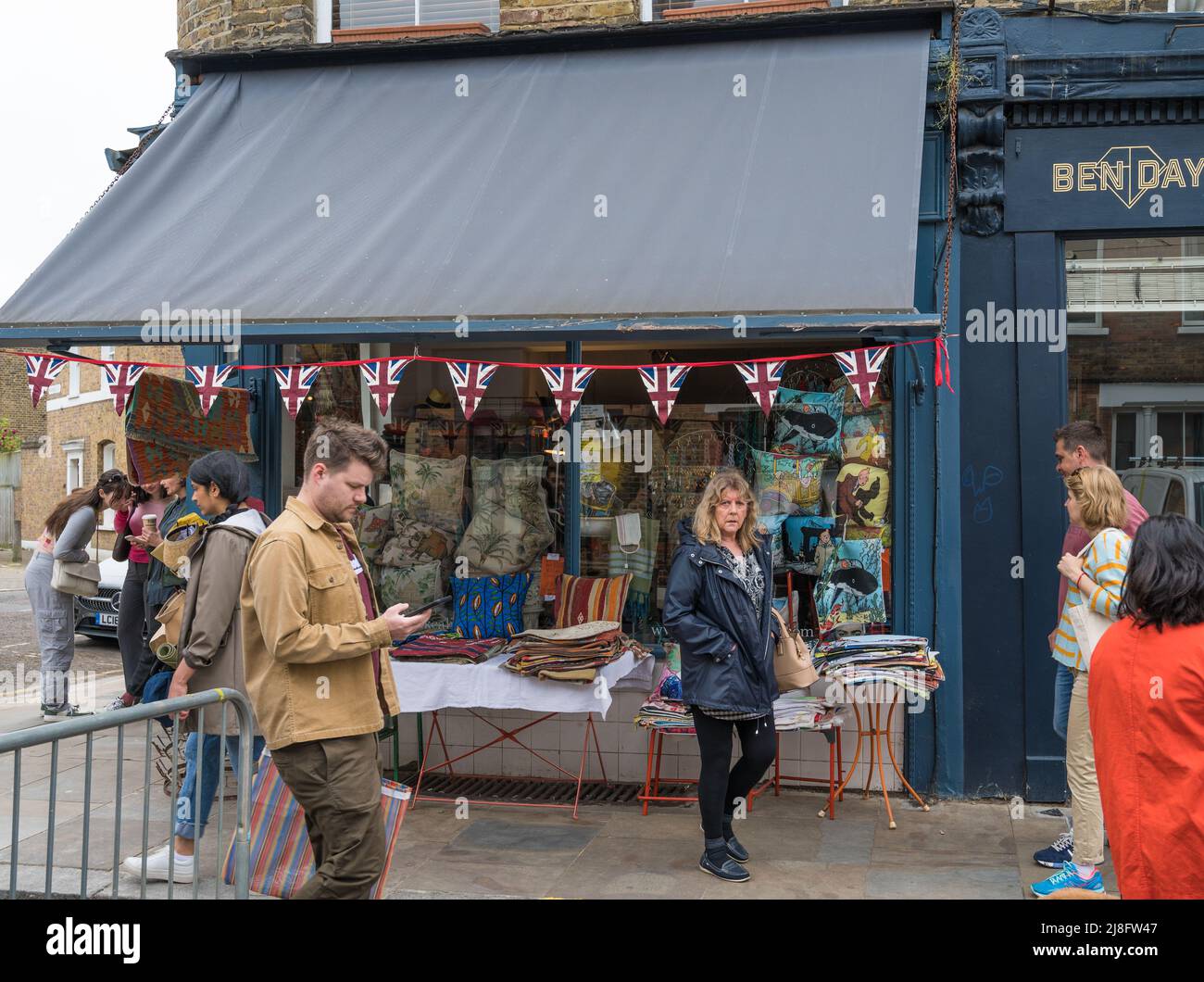 People out and about shopping in the street of small Victorian shops on ...