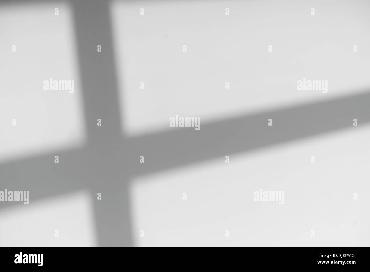 Shadows of window lines on a concrete stone wall in a bright room ...