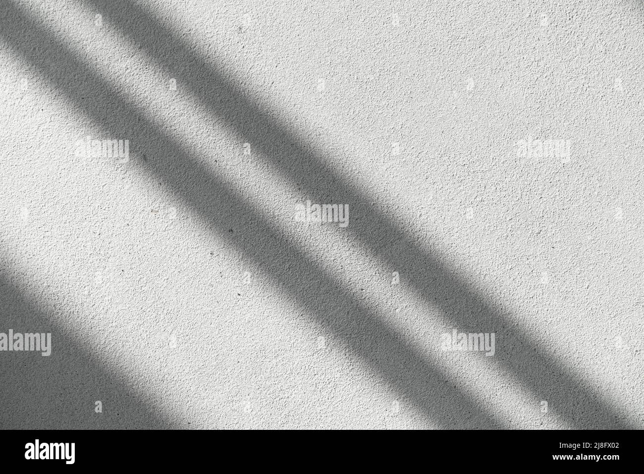 Shadows of window lines on a concrete stone wall in a bright room ...