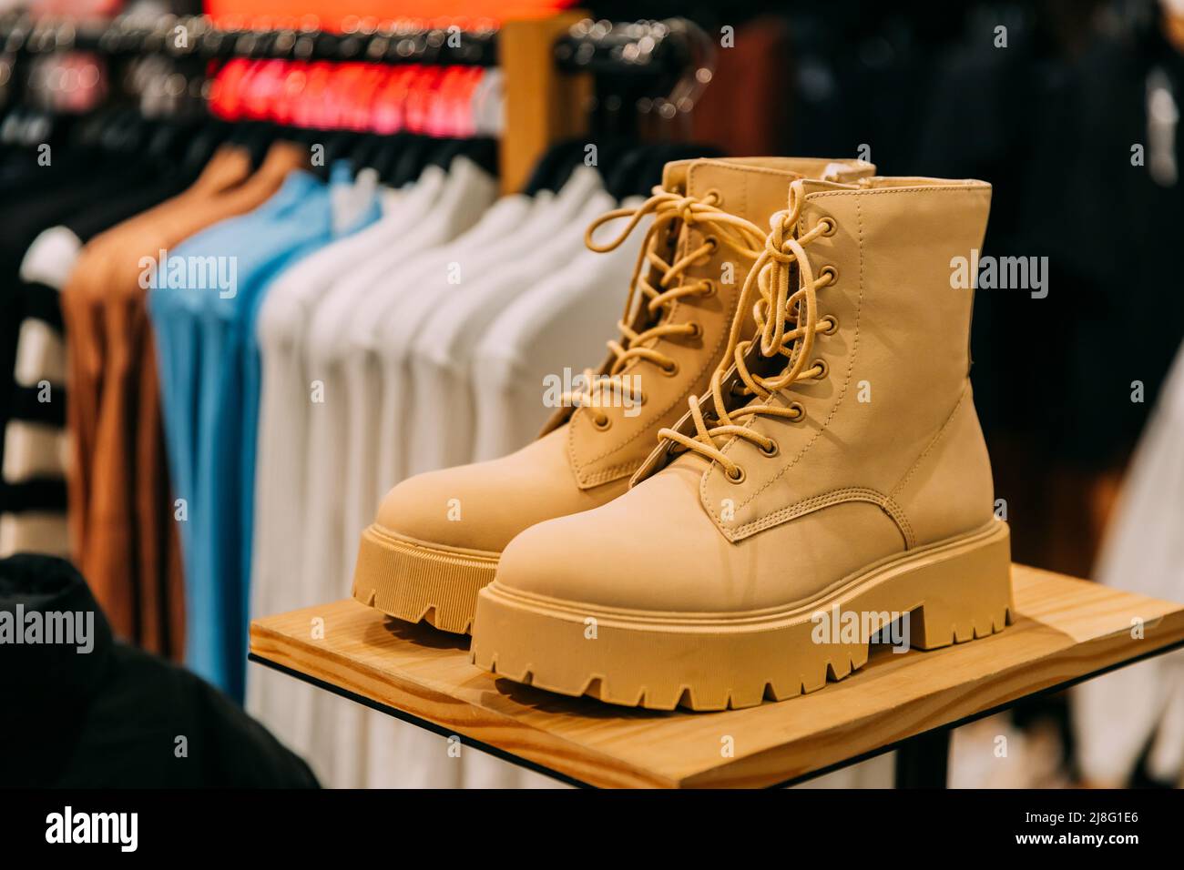 yellow leather unisex boots on shelf display in shop mall store. Store ...