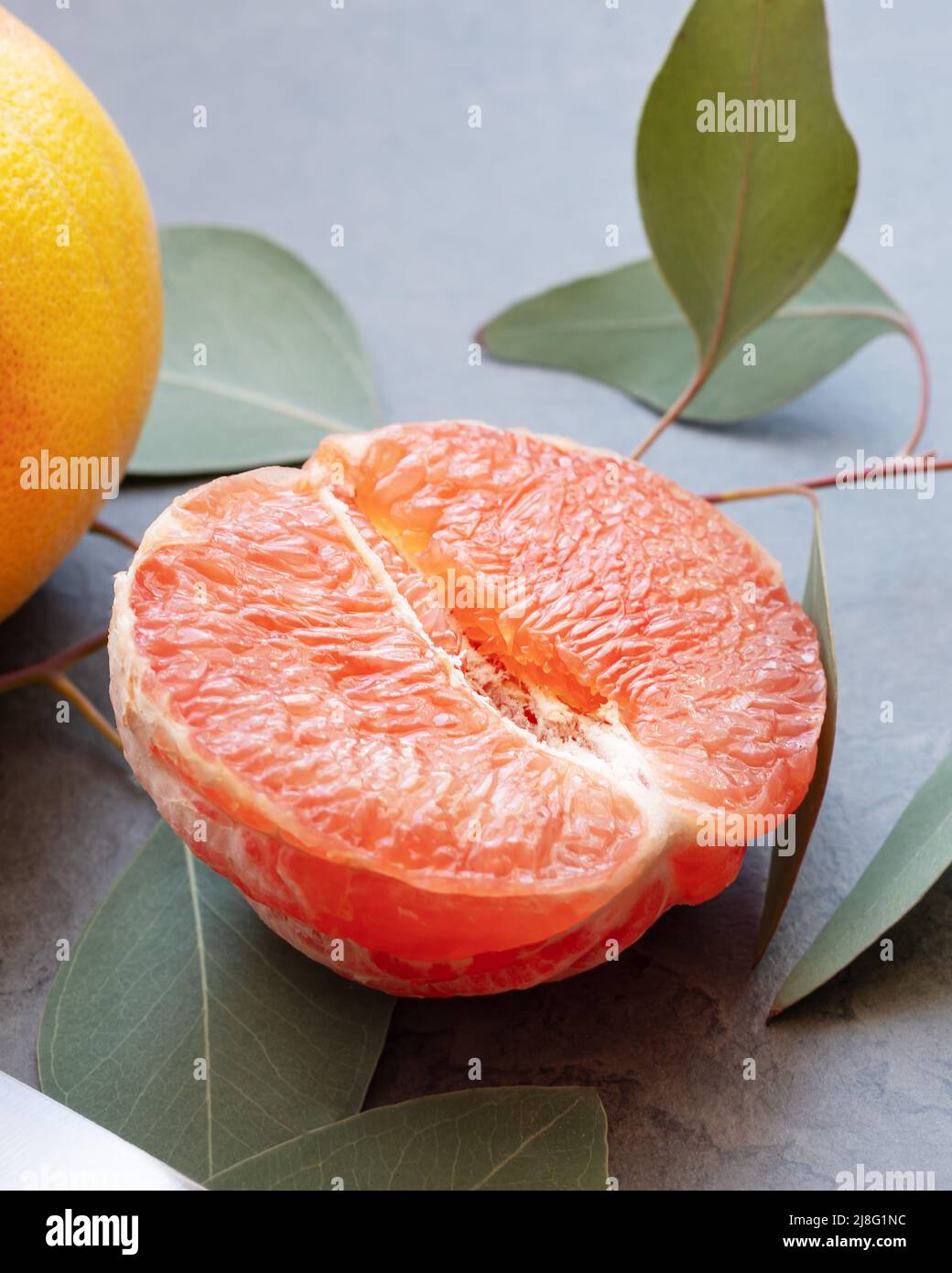 Half a fresh, juicy natural grapefruit on dark marble background with ...