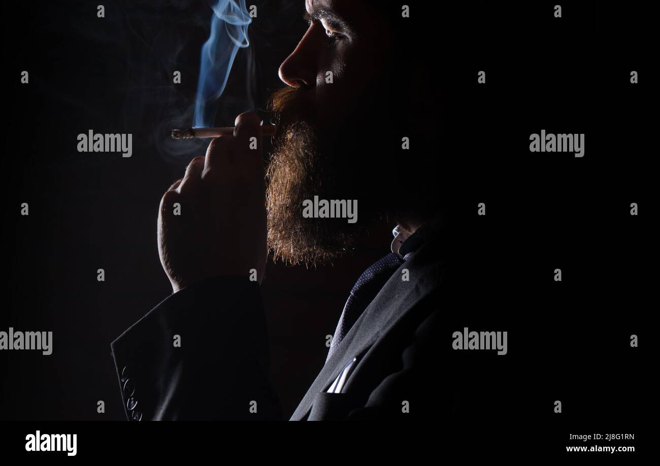 Dark shadow on face young man smoking over a black background. Man ...