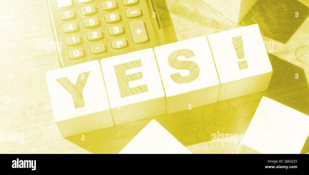 The word Yes on wooden blocks and calculator. Business, motivation and ...