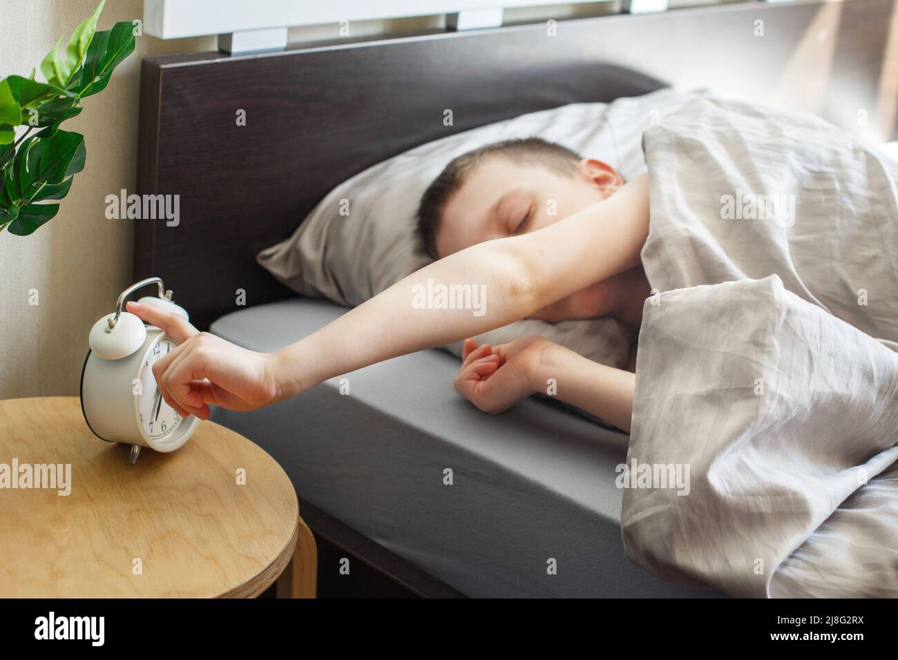Child turning off alarm clock hi-res stock photography and images - Alamy