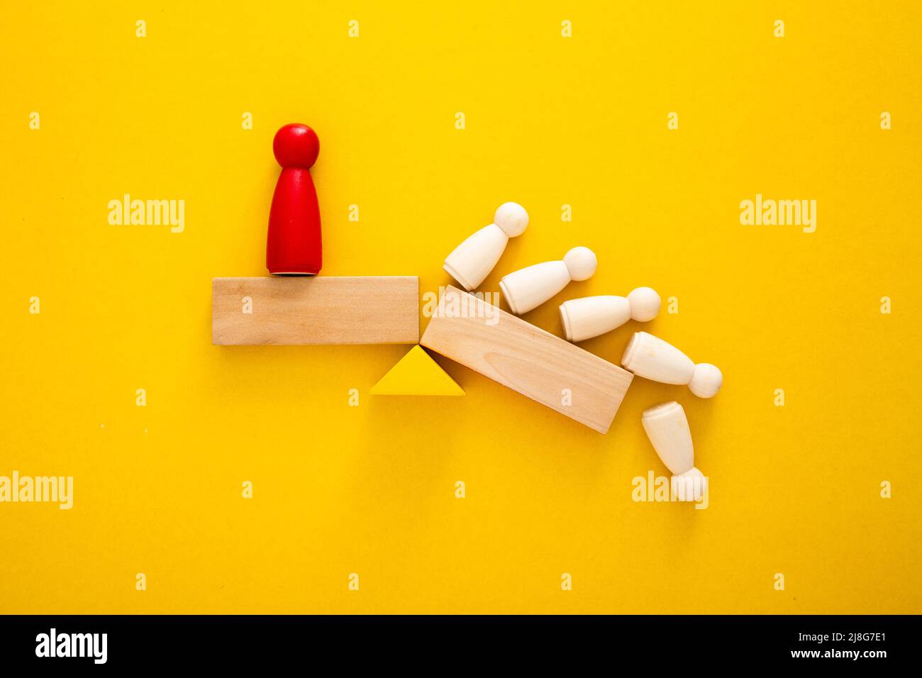 Team standing on a wooden seesaw, one side winner and one side loser ...