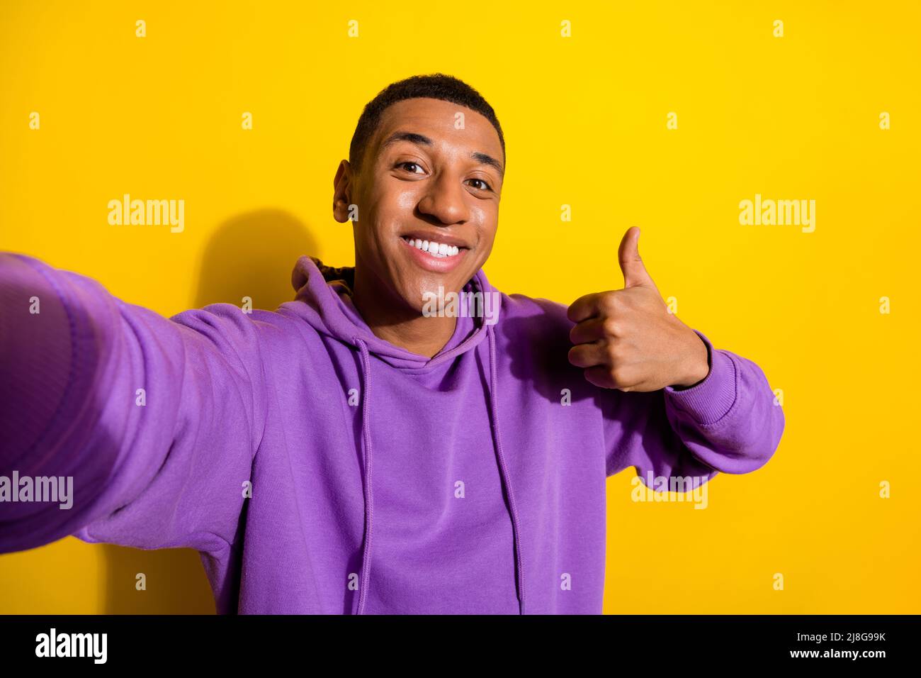 Self portrait of attractive cheerful trendy guy showing thumbup deal ...