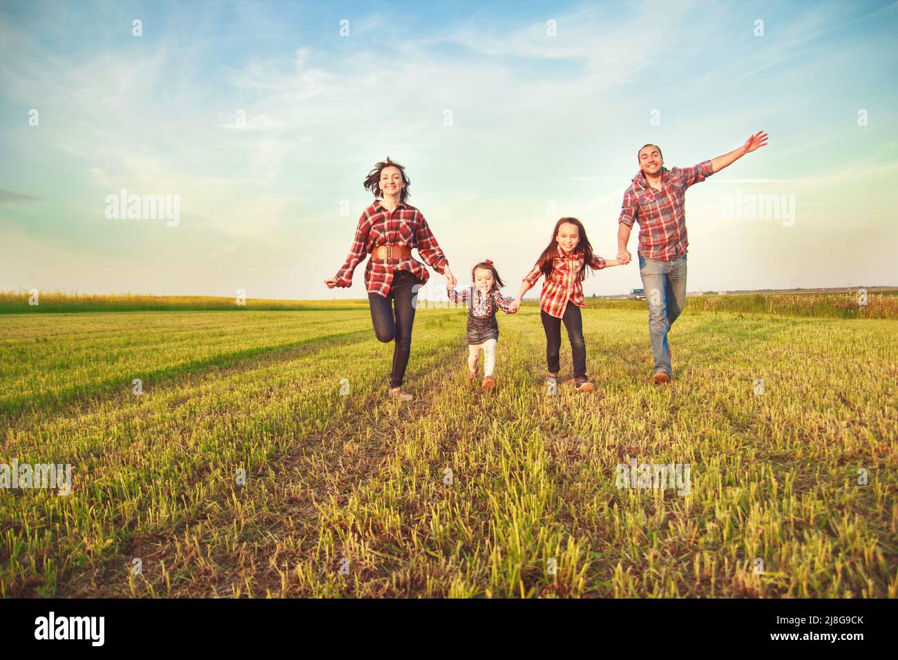 Happy family playing in the green field hi-res stock photography and ...