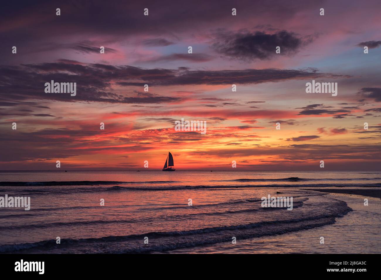 Beautiful tropical beach sunset with yacht at sea. Clouds and clear sky ...