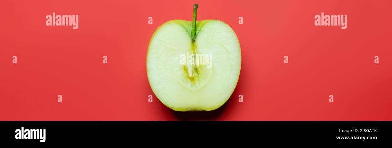 Top view of cut green apple on red background, banner Stock Photo - Alamy