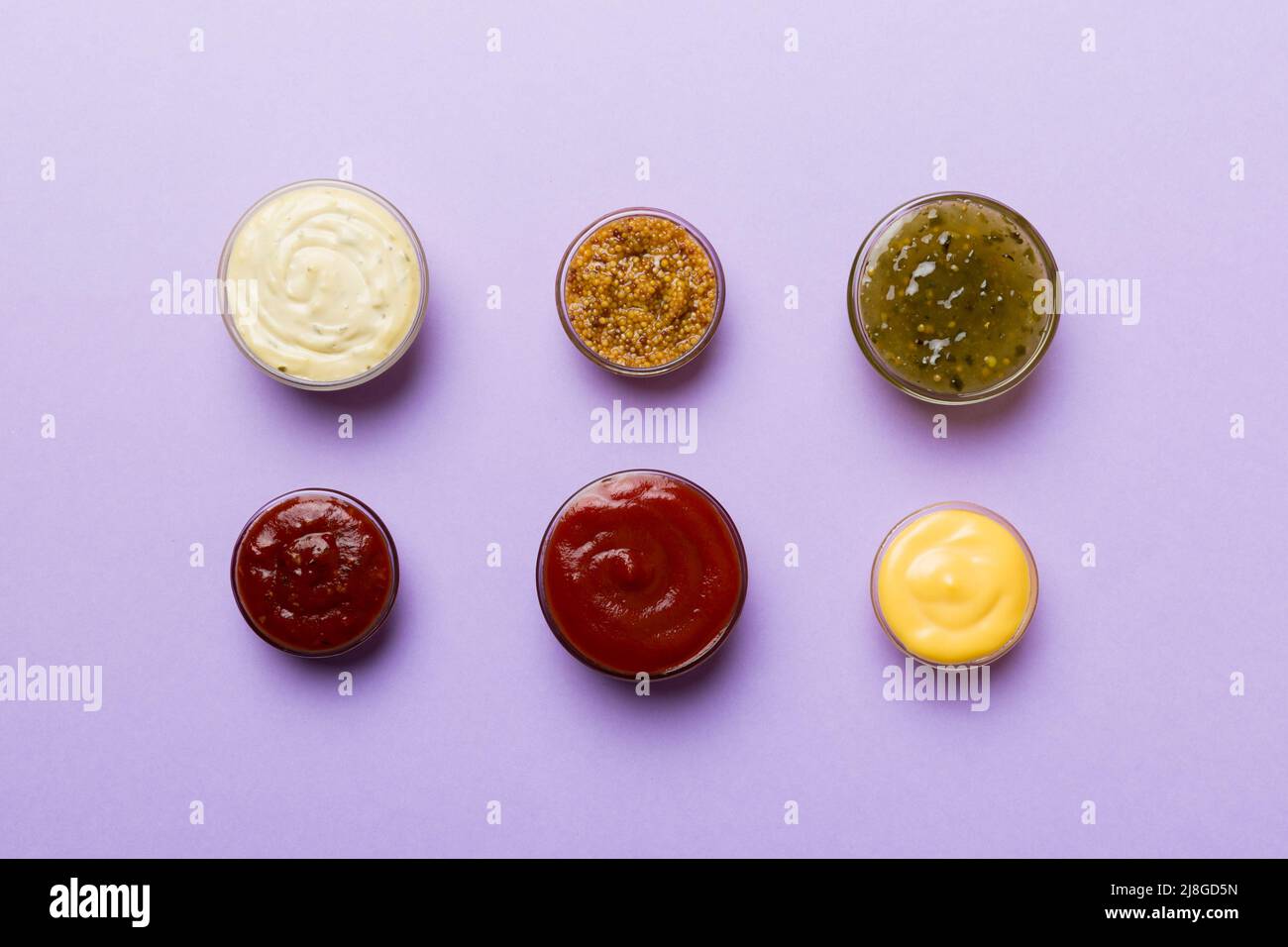 Different types of sauces in bowls on a colored Board . Top view ...