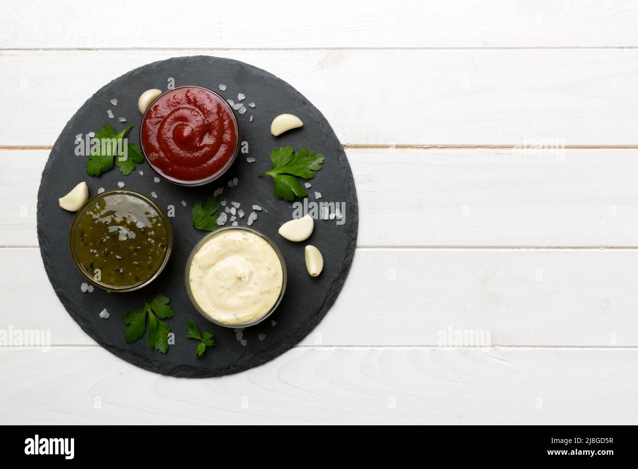 Many different sauces and herbs on table, flat lay top view. sauces on ...