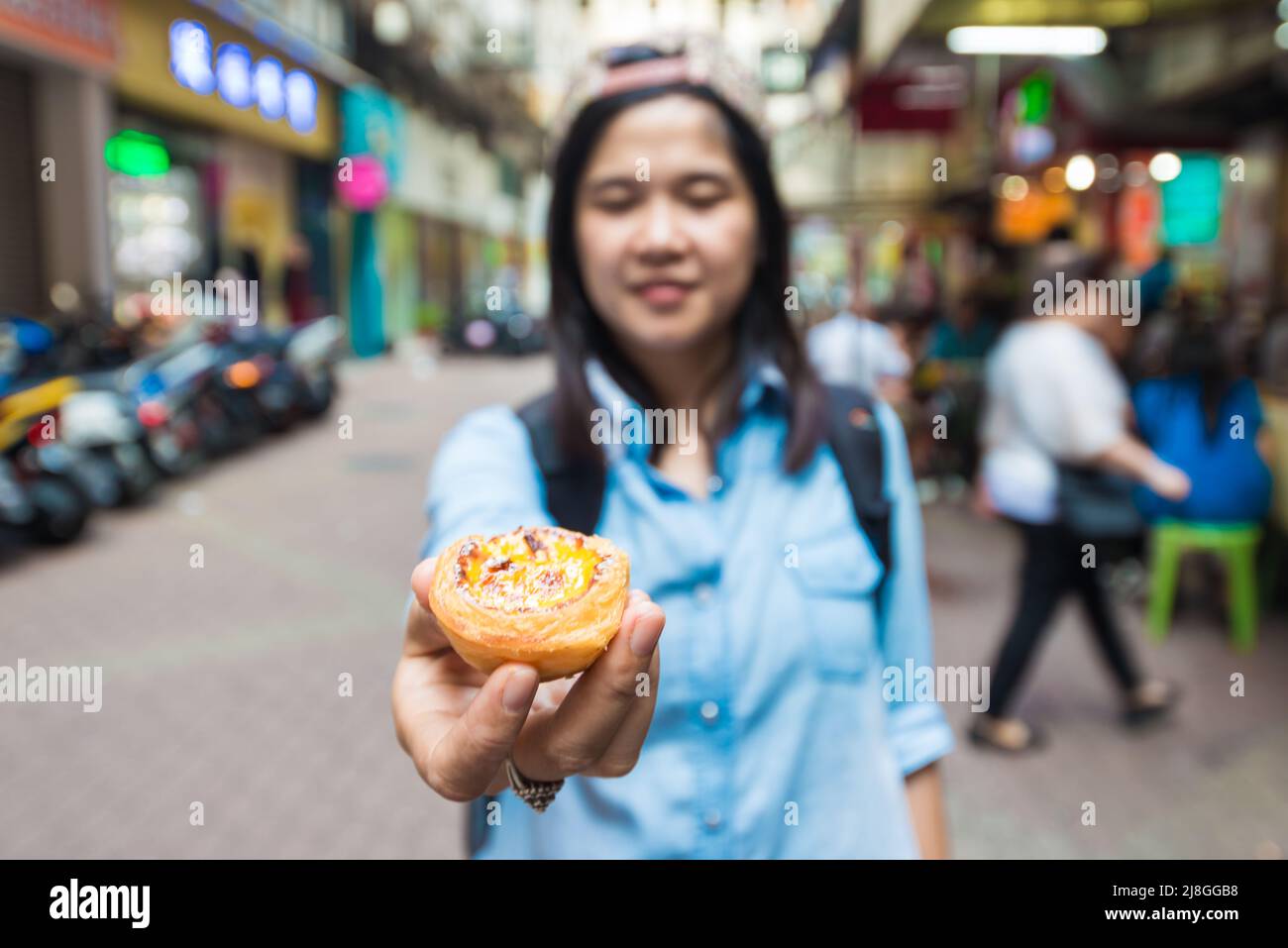 Women with egg tart famous local sweet in Macau, China Stock Photo - Alamy
