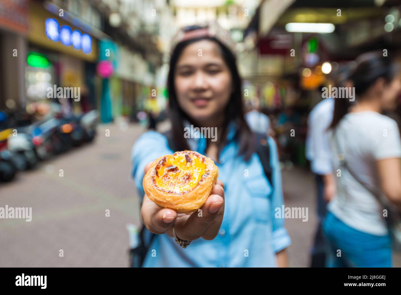 Women with egg tart famous local sweet in Macau, China Stock Photo - Alamy