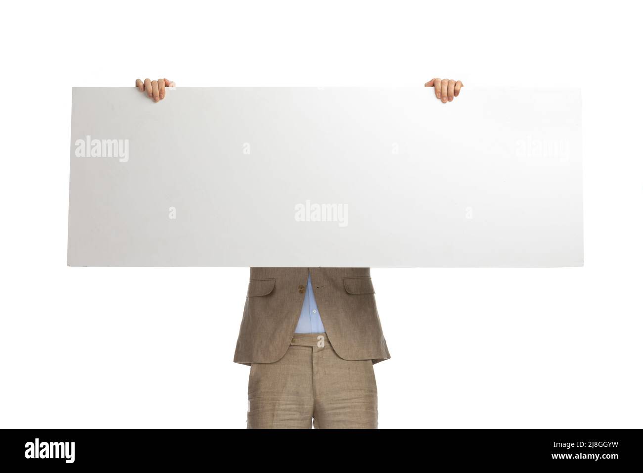 man in beige suit covering face with empty white board on white ...
