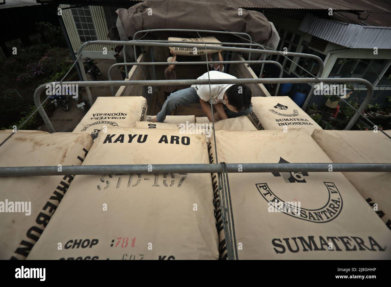 Workers loading tea sacks onto a truck at Kayu Aro tea factory in ...