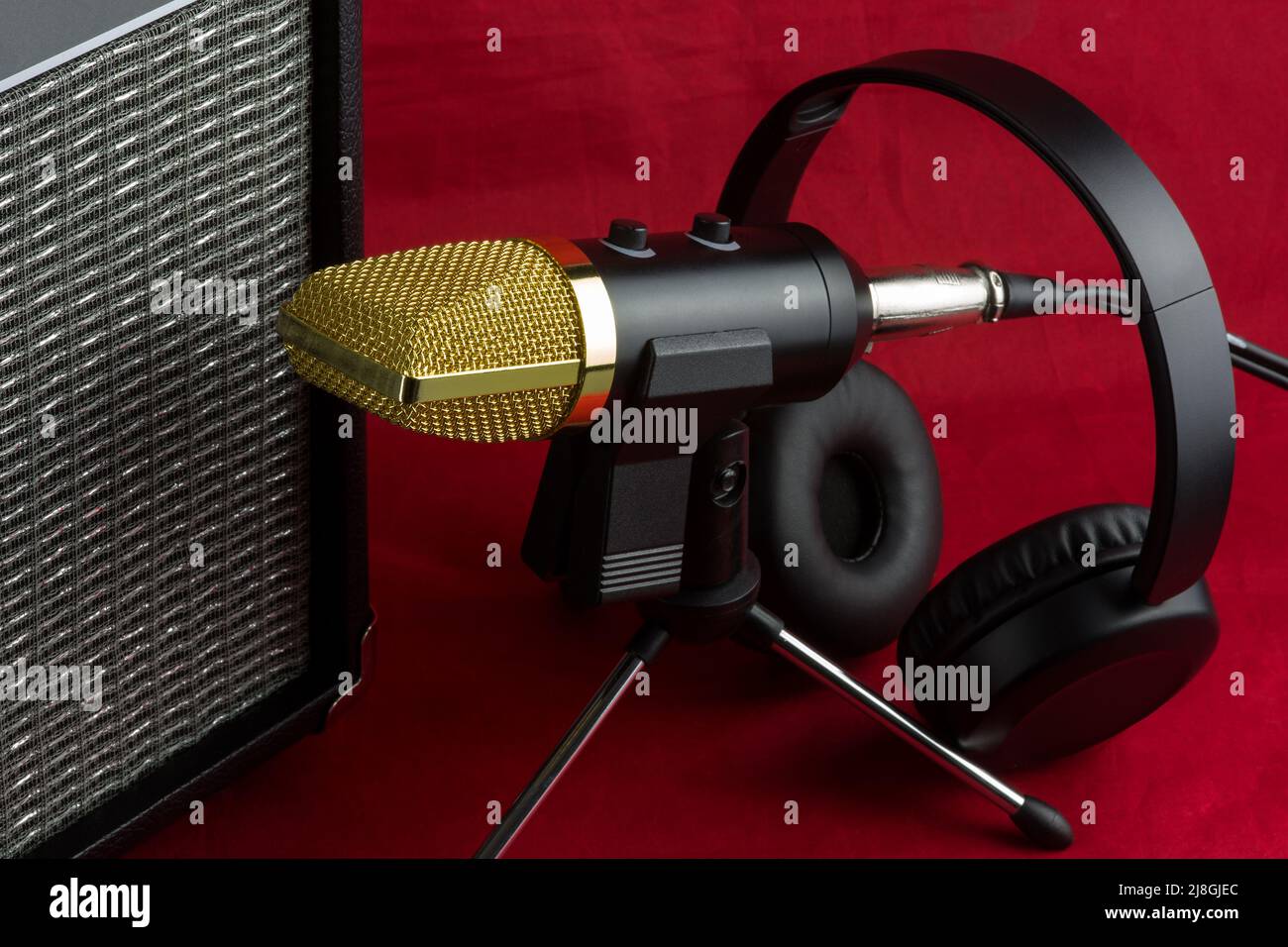 Amplifier with headphones and microphone against a red cloth background ...
