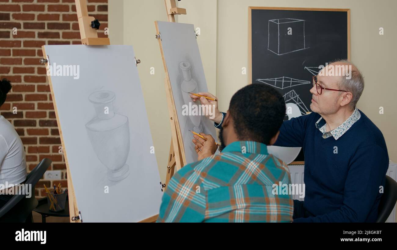 Team of students drawing vase model on canvas in art class to learn new ...