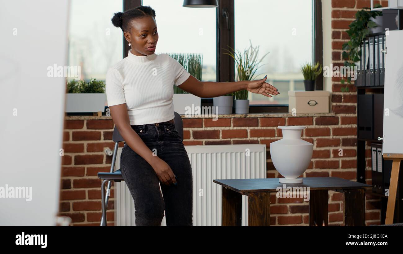 African american teacher explaining artistic inspiration in art class ...