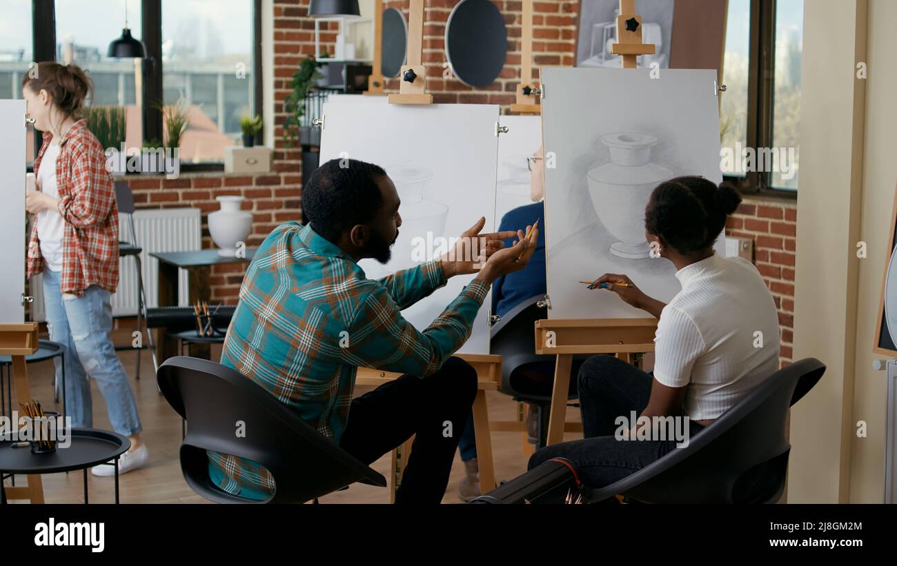 Man and woman attending art class lesson to develop drawing skills and ...