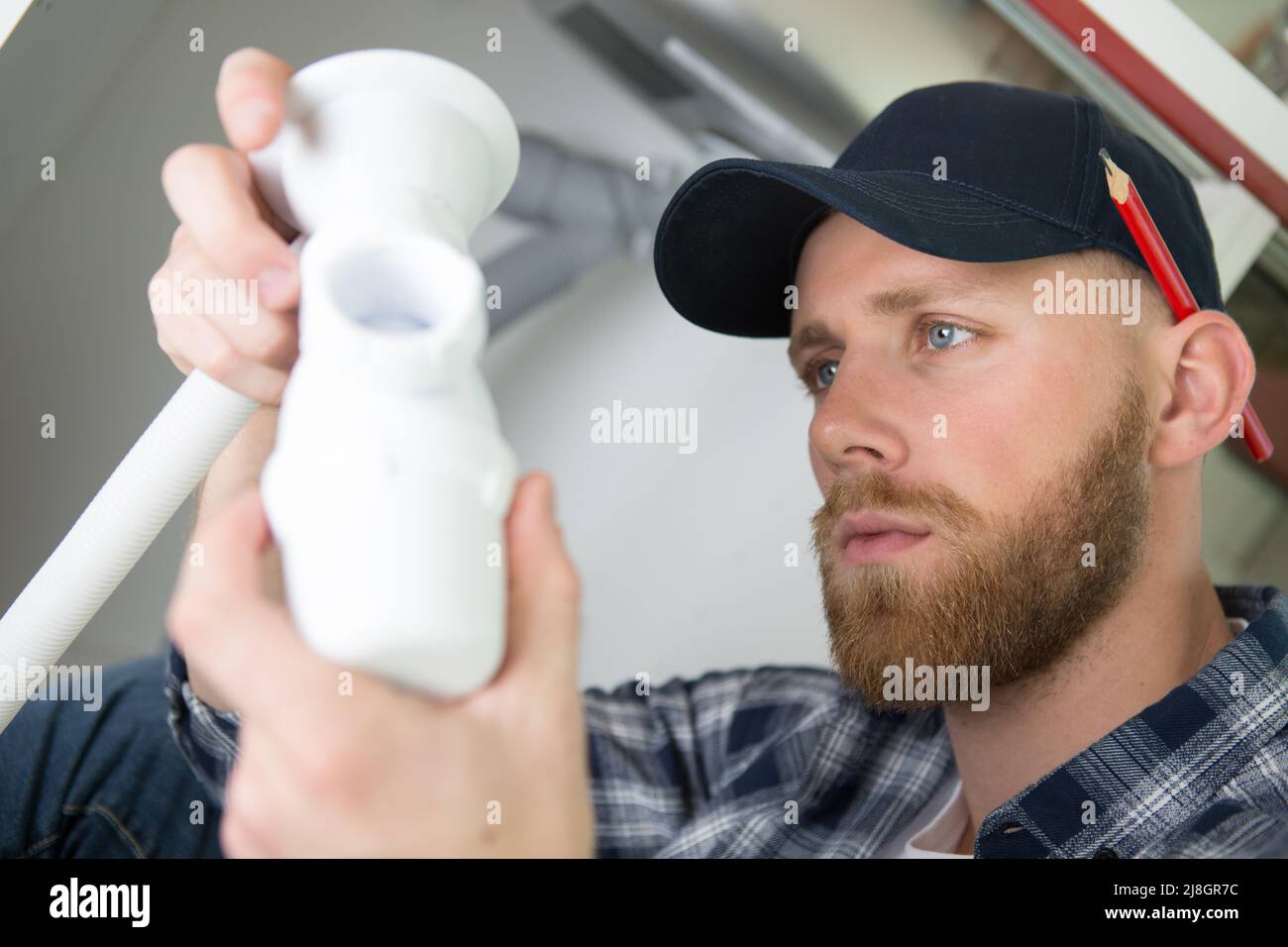 plumber assembling plastic waste water siphon Stock Photo - Alamy