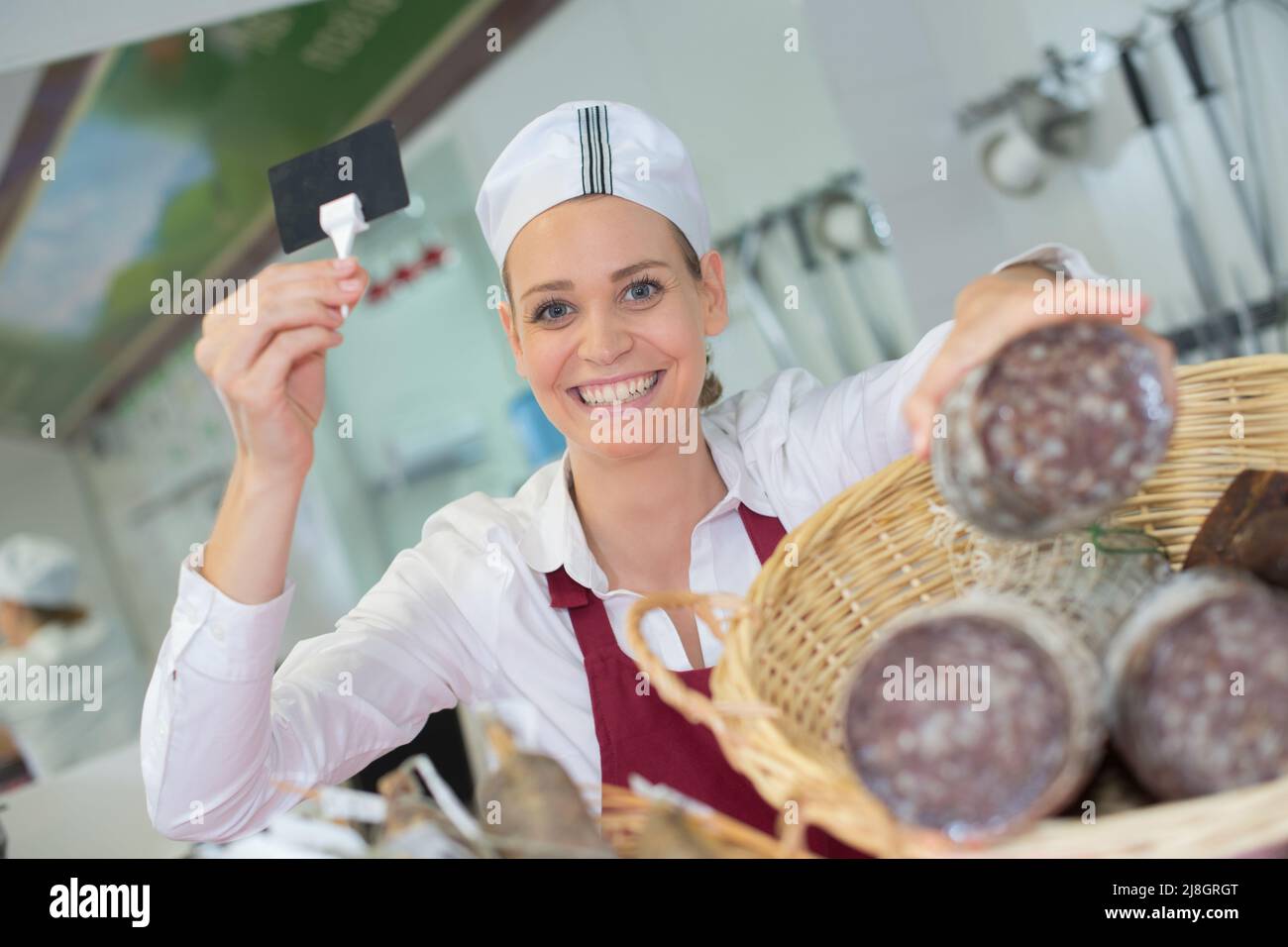 saleswoman with blond hair presenting italian salami Stock Photo - Alamy