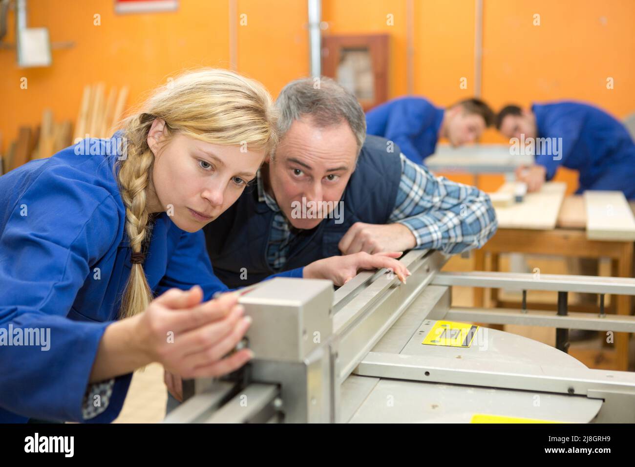 woodworking female apprentice inspecting a workbench Stock Photo - Alamy