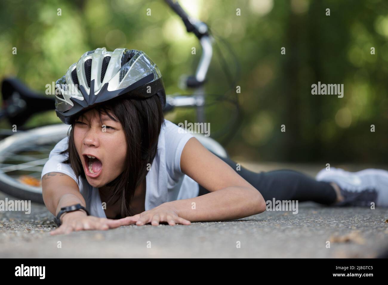 crying young woman after falling from a bike Stock Photo - Alamy