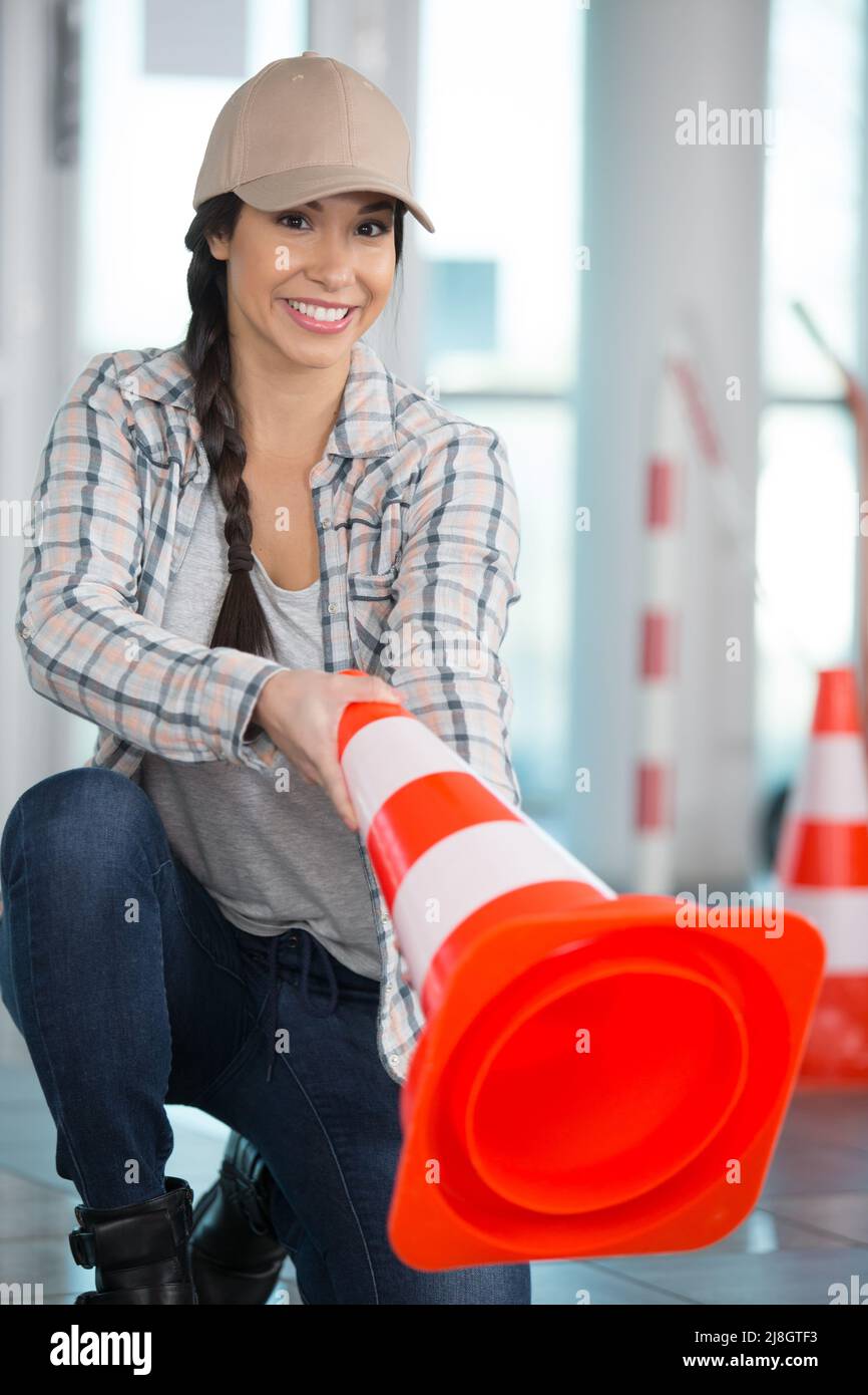 happy female builder holding traffic cone Stock Photo - Alamy