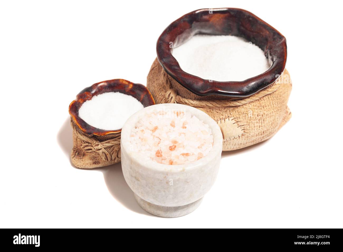Bowls of white table salt and large crystals pink Himalayan salt ...