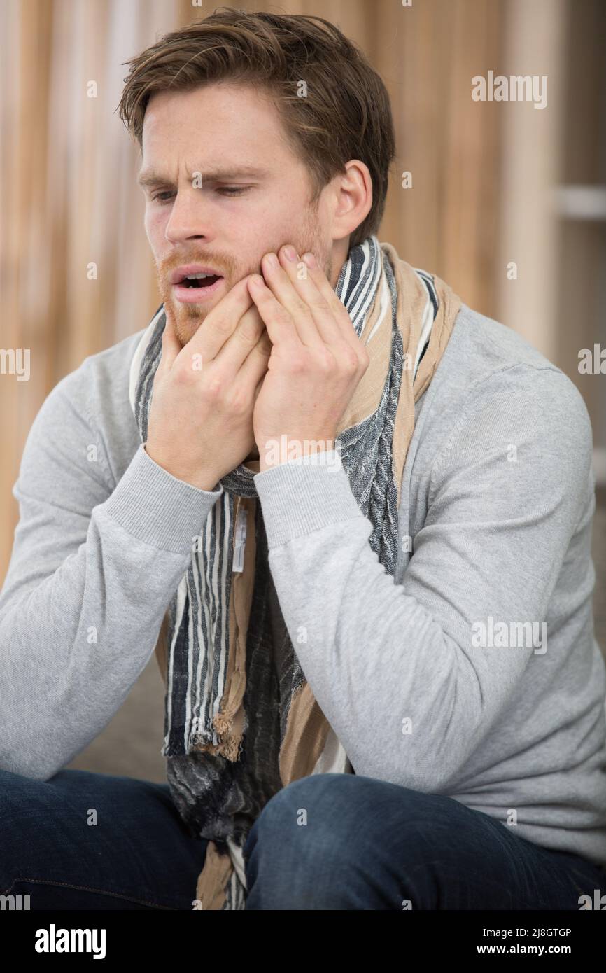 man holds his hand near the cheek toothache Stock Photo - Alamy