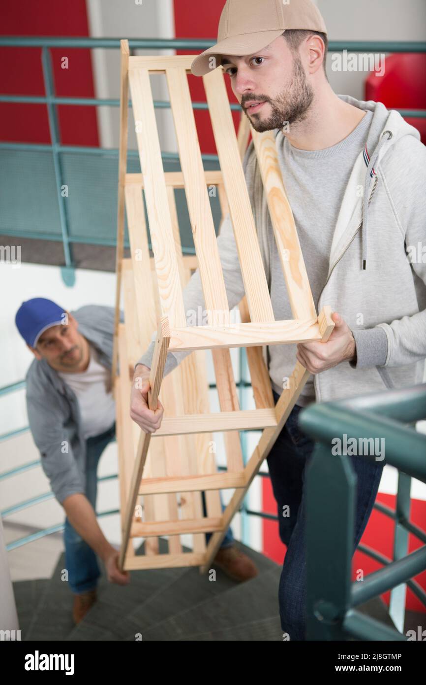men moving upstairs a wooden shelf Stock Photo - Alamy