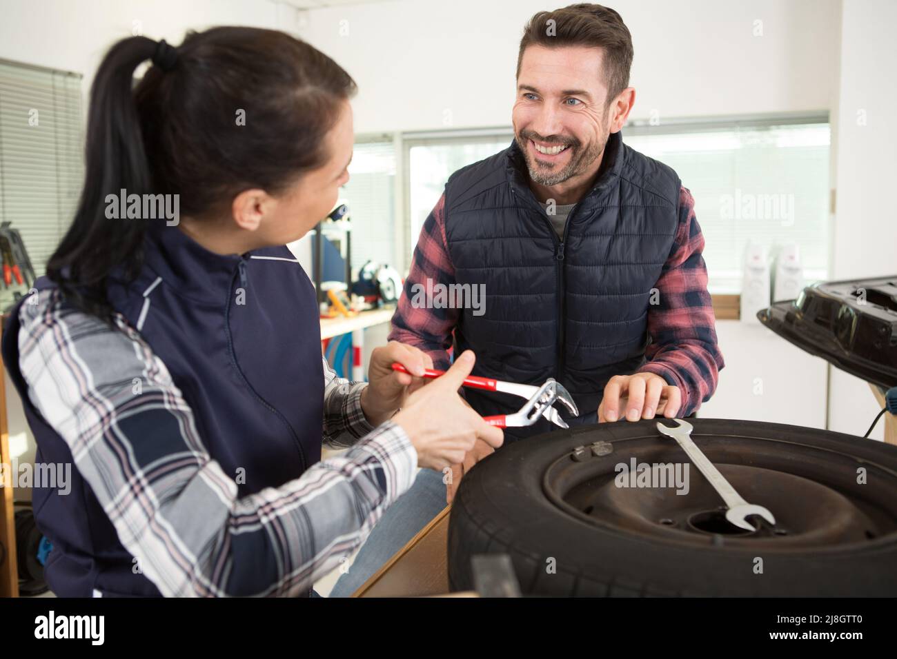 female engineer using pliers to work on tyre Stock Photo - Alamy