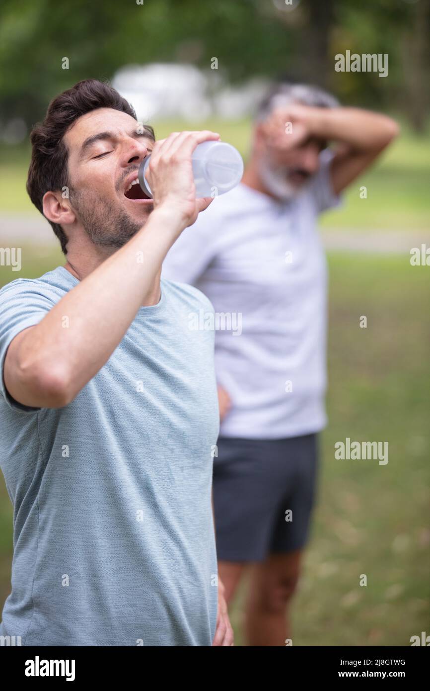 men drinking water outdoors after running Stock Photo - Alamy