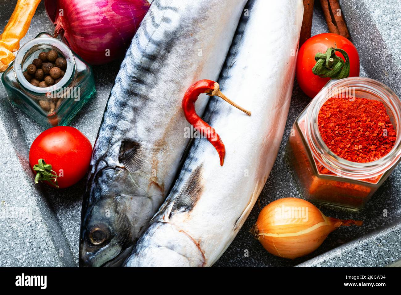 Raw mackerel fish and spices on the kitchen table. Uncooked fish Stock ...