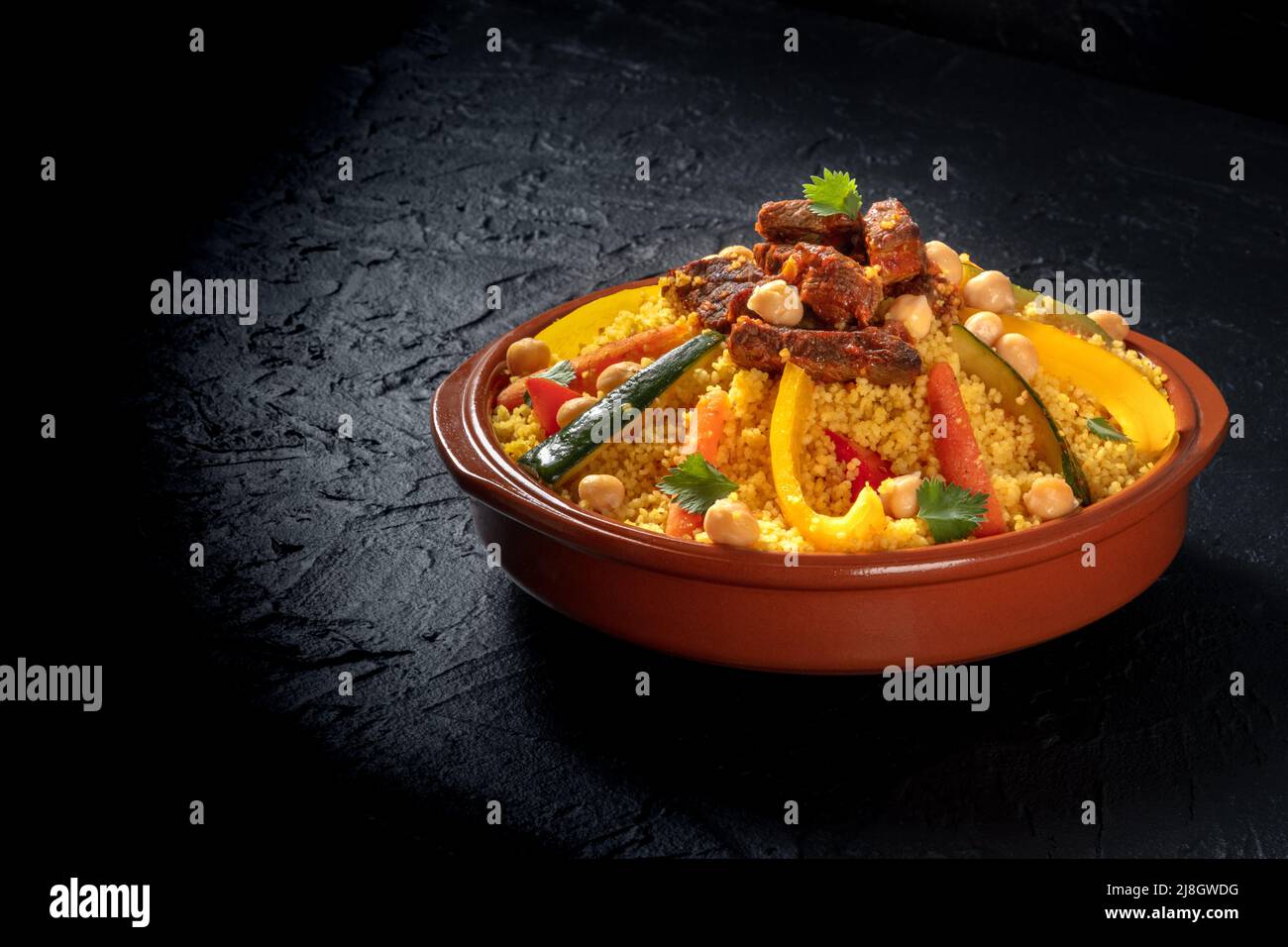 Meat and vegetable couscous, festive African food, on a dark background ...