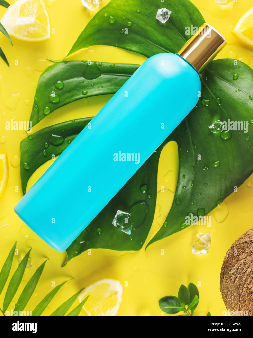 Blue shampoo bottle with slices of citrus fruits, ice cubes and exotic ...