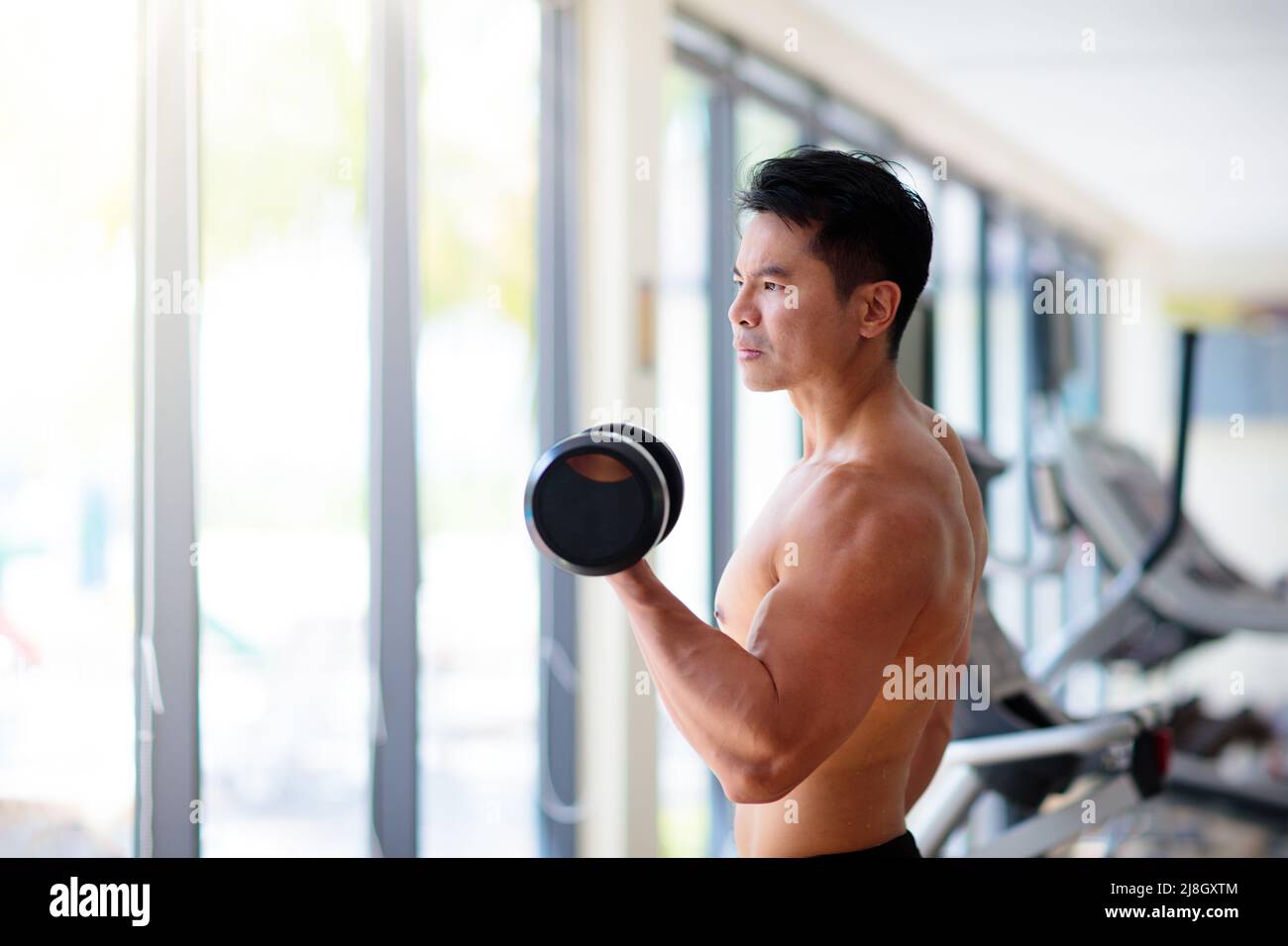 Man exercising in gym. Asian bodybuilder lifting weights. Sport and ...