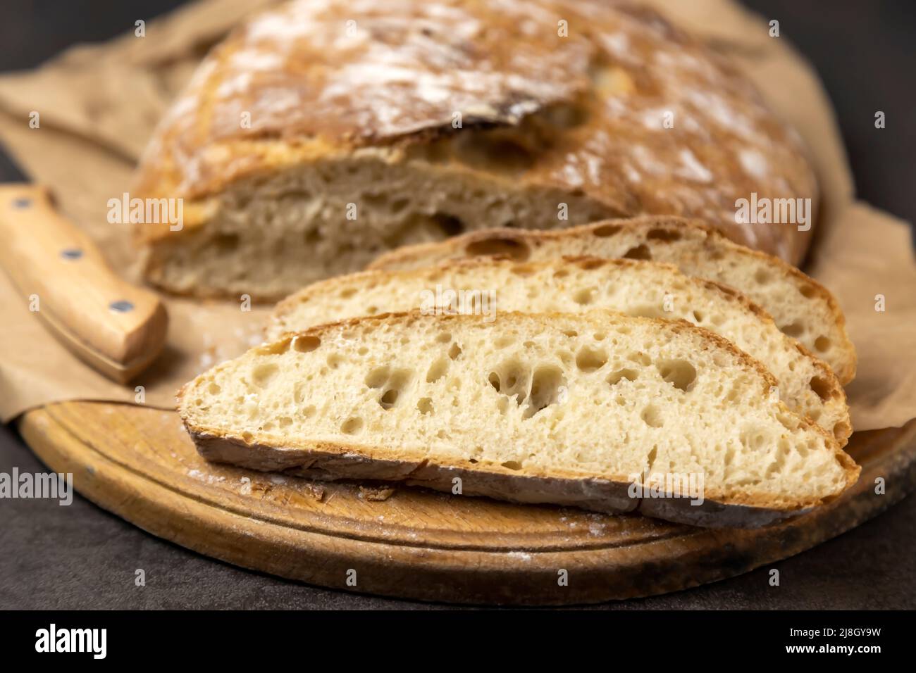 White sliced bread and knife. A loaf of bread with the first half ...