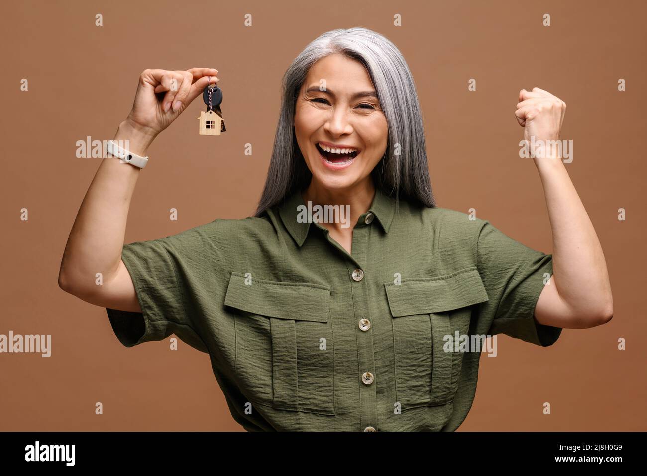 Happy overjoyed senior woman holding keys with keychain in form of ...