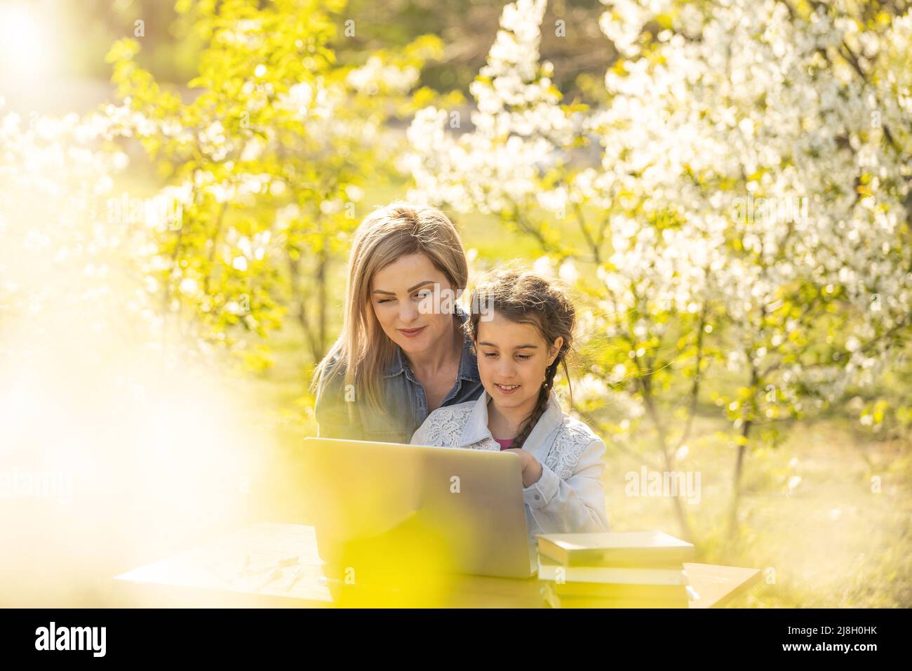 little girl with mom learning on laptop outdoor Stock Photo - Alamy