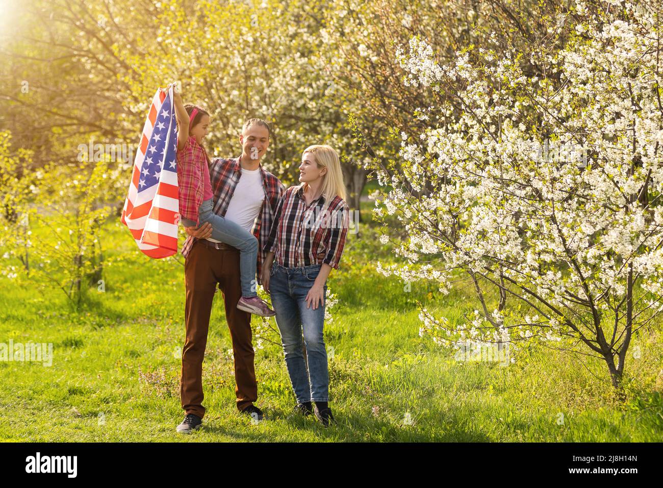 July 4th: American Family Behind US Flag Stock Photo - Alamy