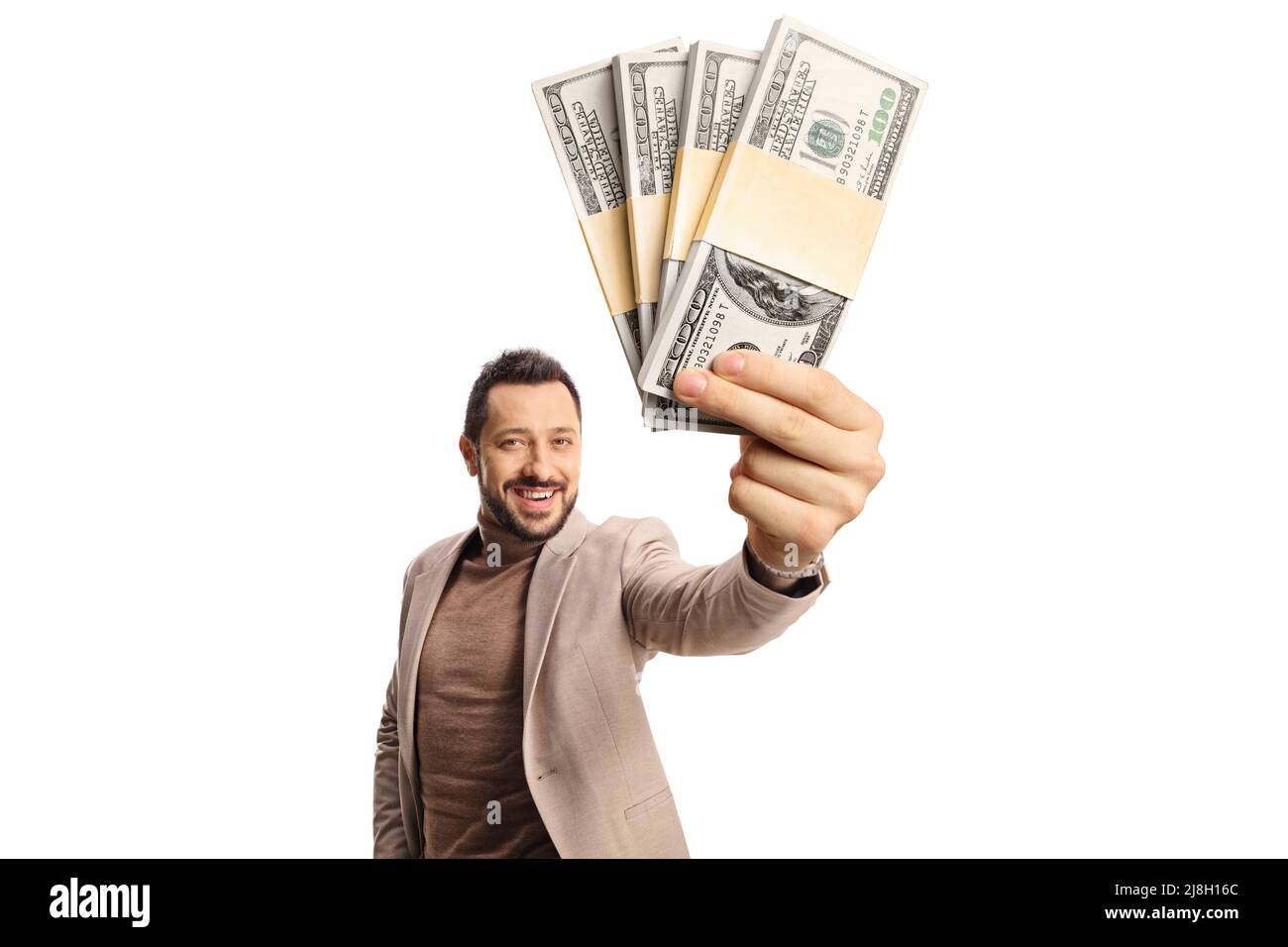 Happy young man holding stacks of banknotes isolated on white ...