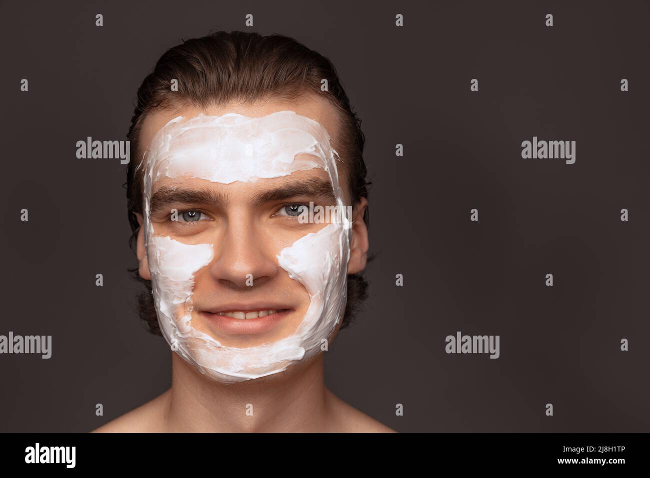 Moisturizing face mask. One man with perfect well-kept skin using face ...