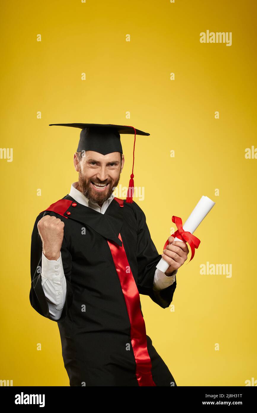 Front view of handsome young male holding diploma. Boy wearing ...