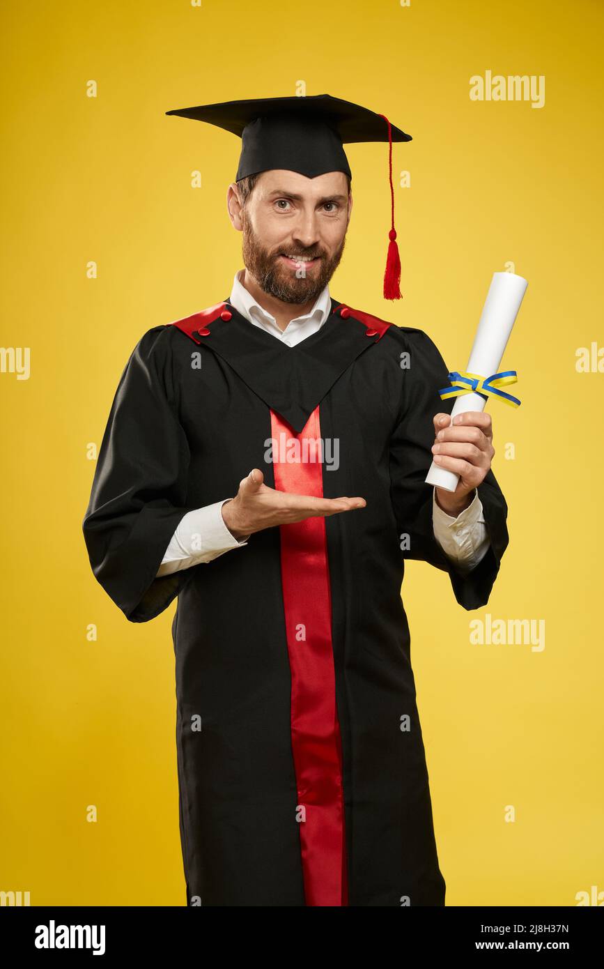 Front view of man wearing graduate gown and mortarboard, showing ...