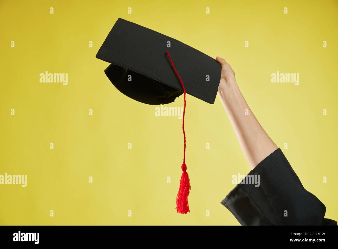 Front view of female hand raising, holding, showing mortarboard. Girl ...
